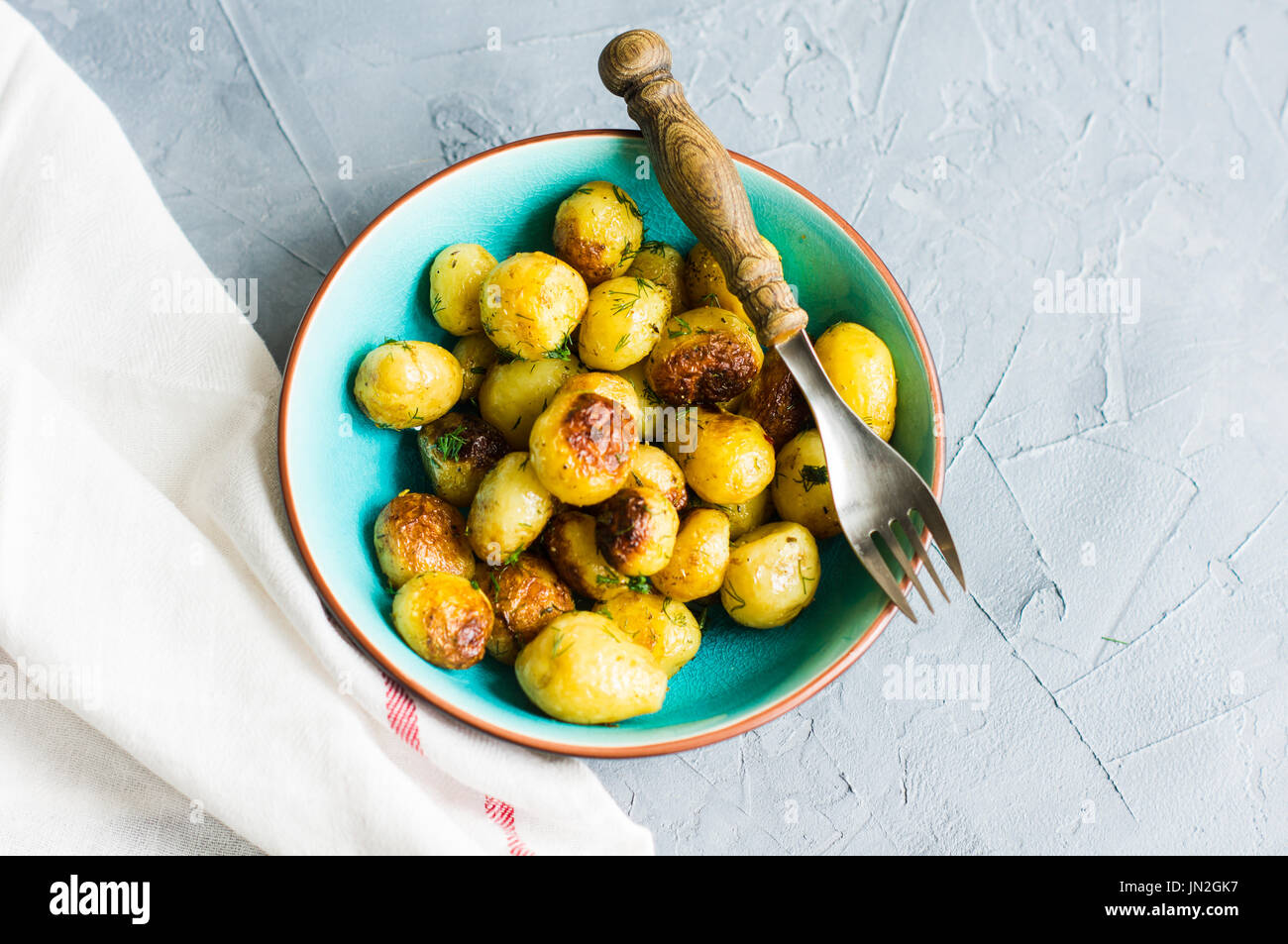 Roast potatoes seasoned with salt, garlic and provance herbs in rustic ...