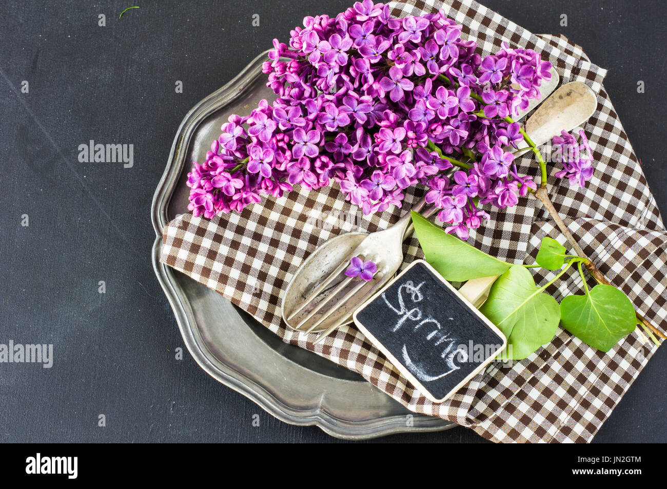 Spring table setting with bright lilac flowers on rustic background ...