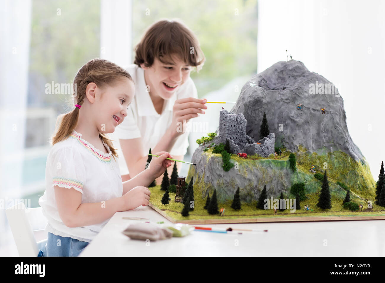 Children work on model building school project. Kids build miniature ...