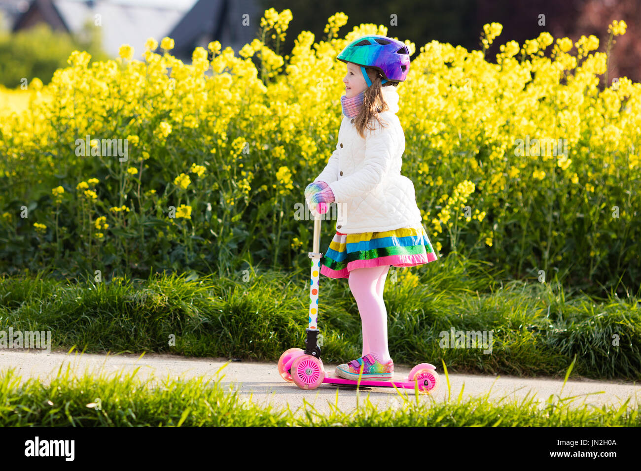 Child riding scooter on way back to school. Little girl playing ...