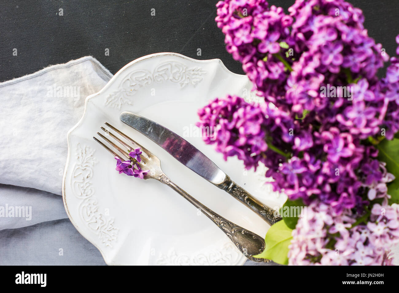 Spring table setting with bright lilac flowers on rustic background ...