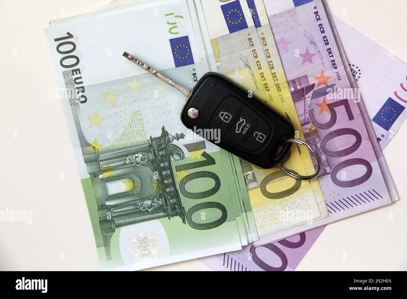Conceptual Euro banknotes with new car Key image on white background ...