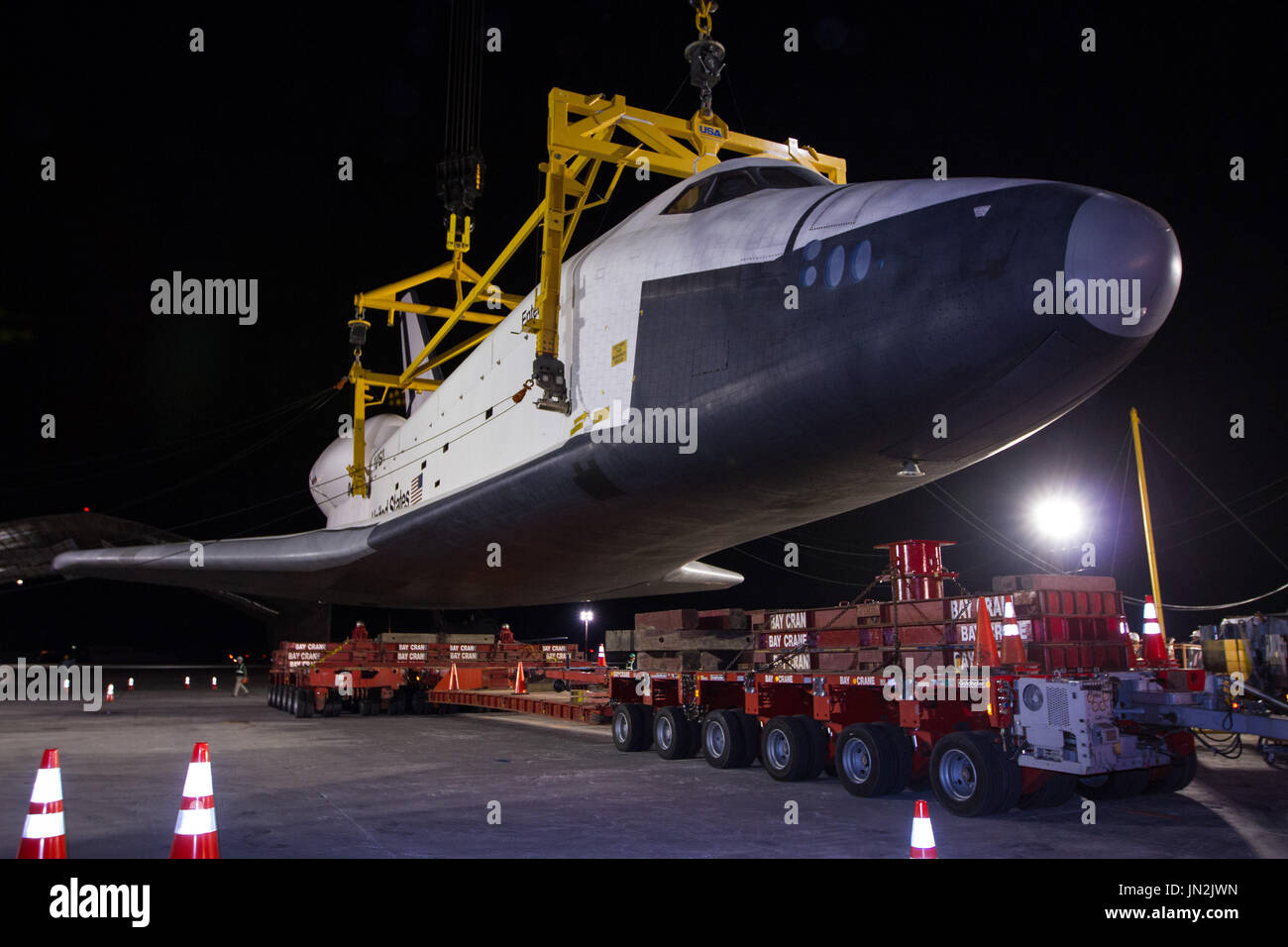 The space shuttle Enterprise is lowered onto a transport vehicle after ...