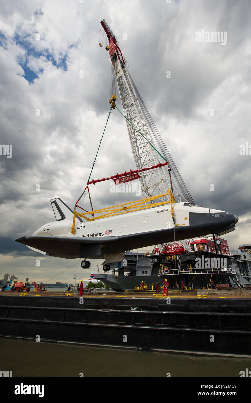 The space shuttle Enterprise is lifted off of a barge and onto the ...