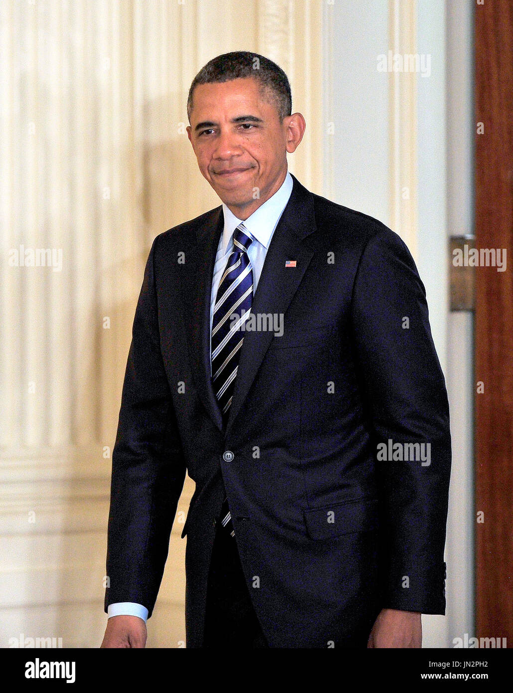 United States President Barack Obama smiles as he enters the East Room ...