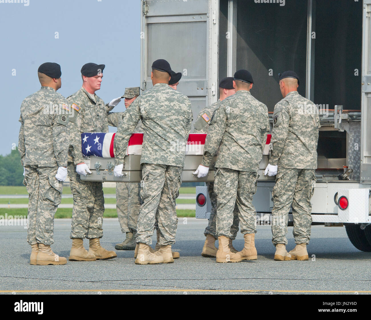 A member of the United States Army transfer team salutes as the ...