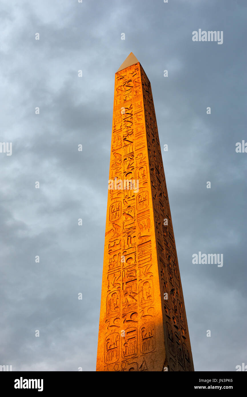 Concorde Obelisk in orange light from sunset against cloudy sky in ...
