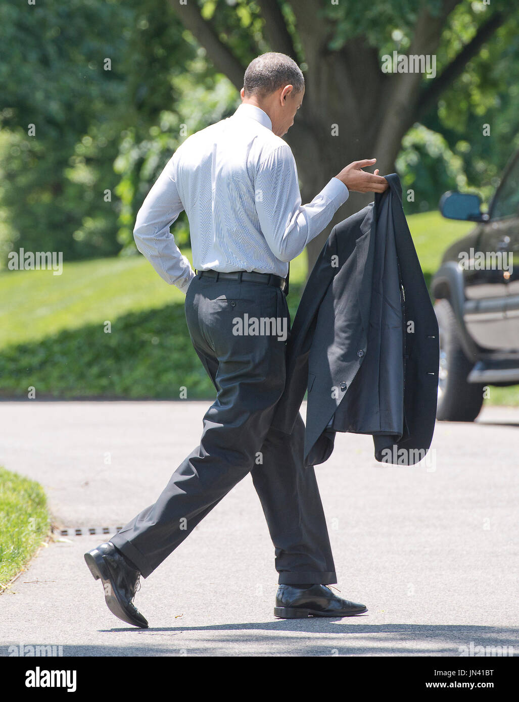 United States President Barack Obama removes his suit jacket as he ...