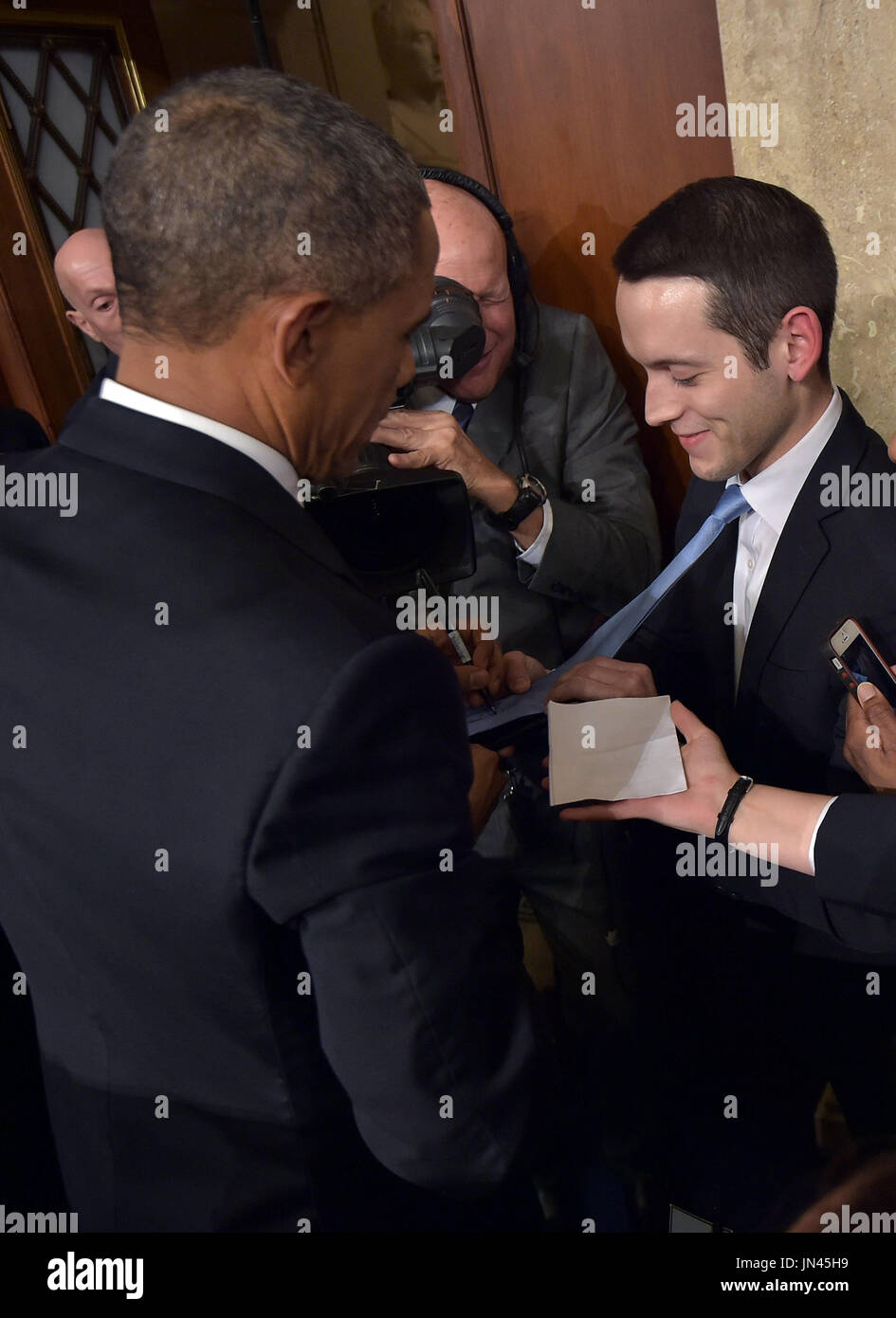 US President Barack Obama signs a tie after delivering the State of the ...