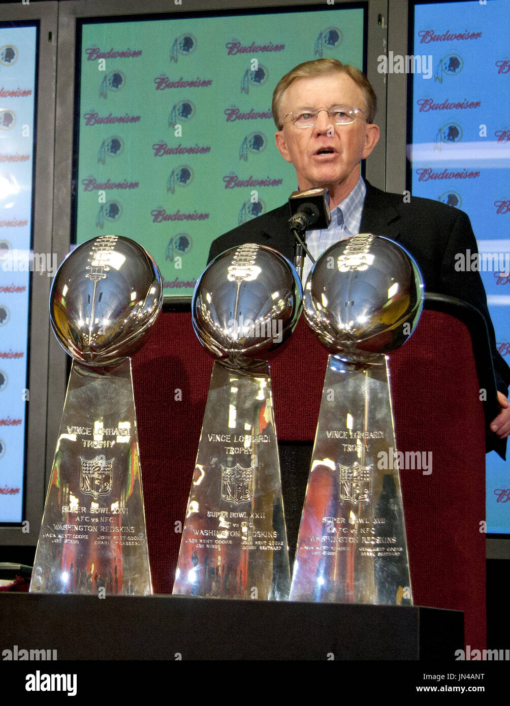 Washington Redskins head coach Joe Gibbs, standing behind the three ...