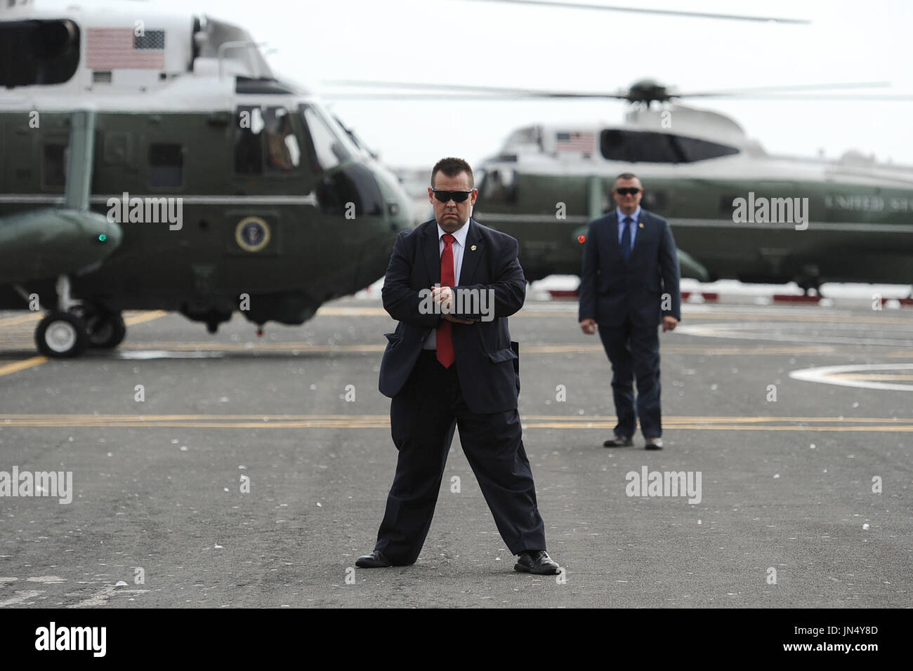 Security detail guard stands near Marine One (on left) carrying United ...