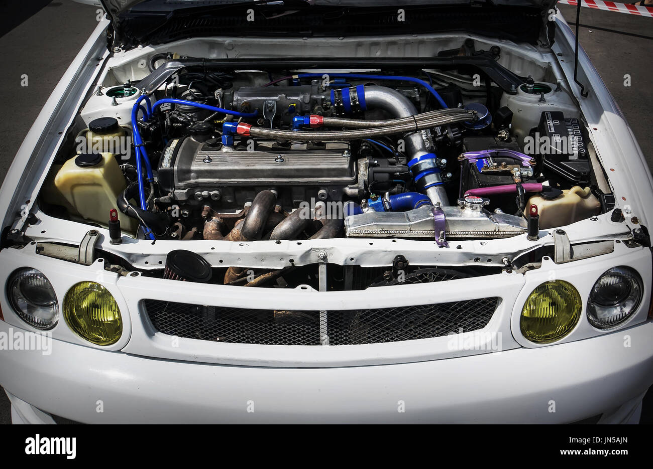 Close up detail of new car engine. White car with open hood in auto ...