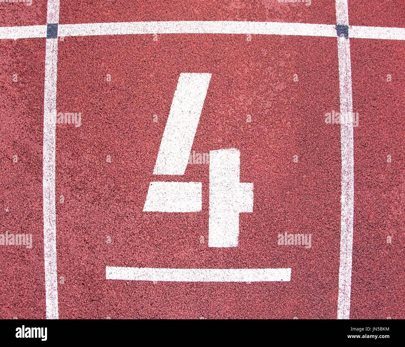 Number four. White track number on red rubber racetrack, texture of ...