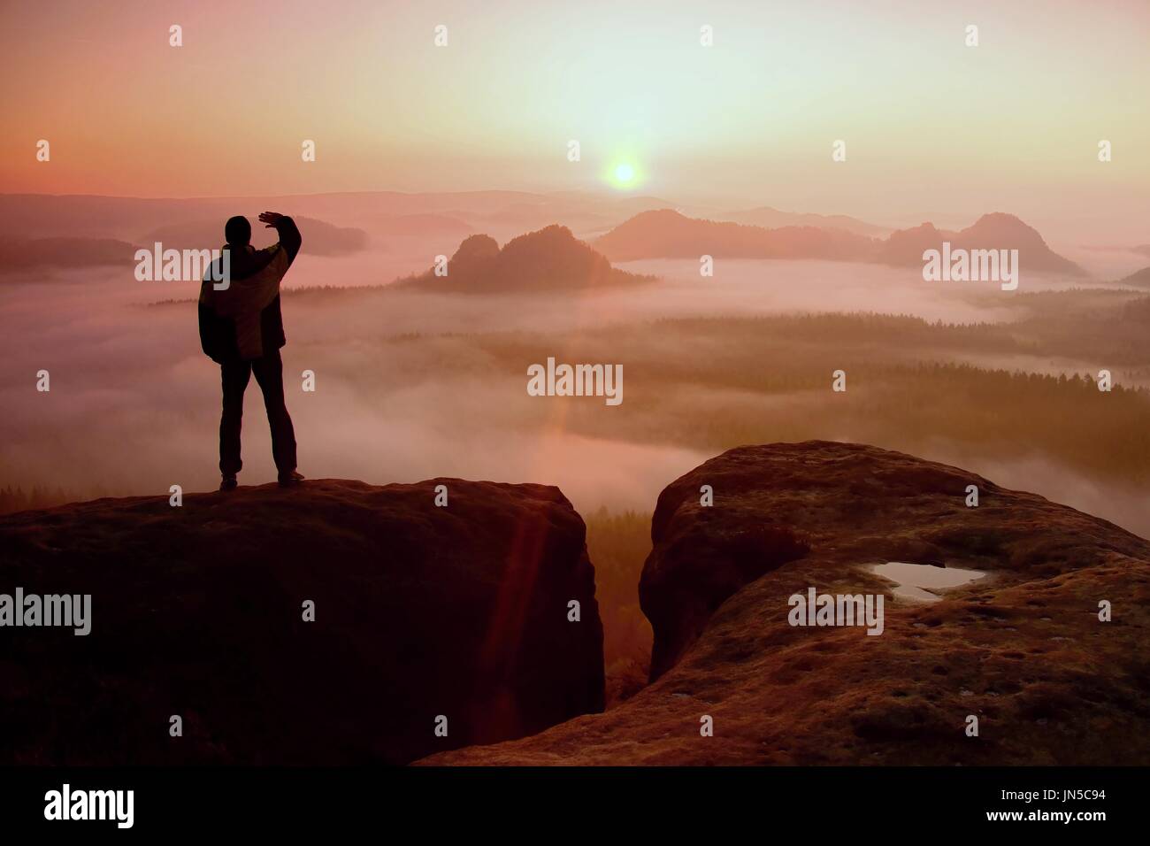 Happy hiker is standing on the peak of rock empires park and watching ...