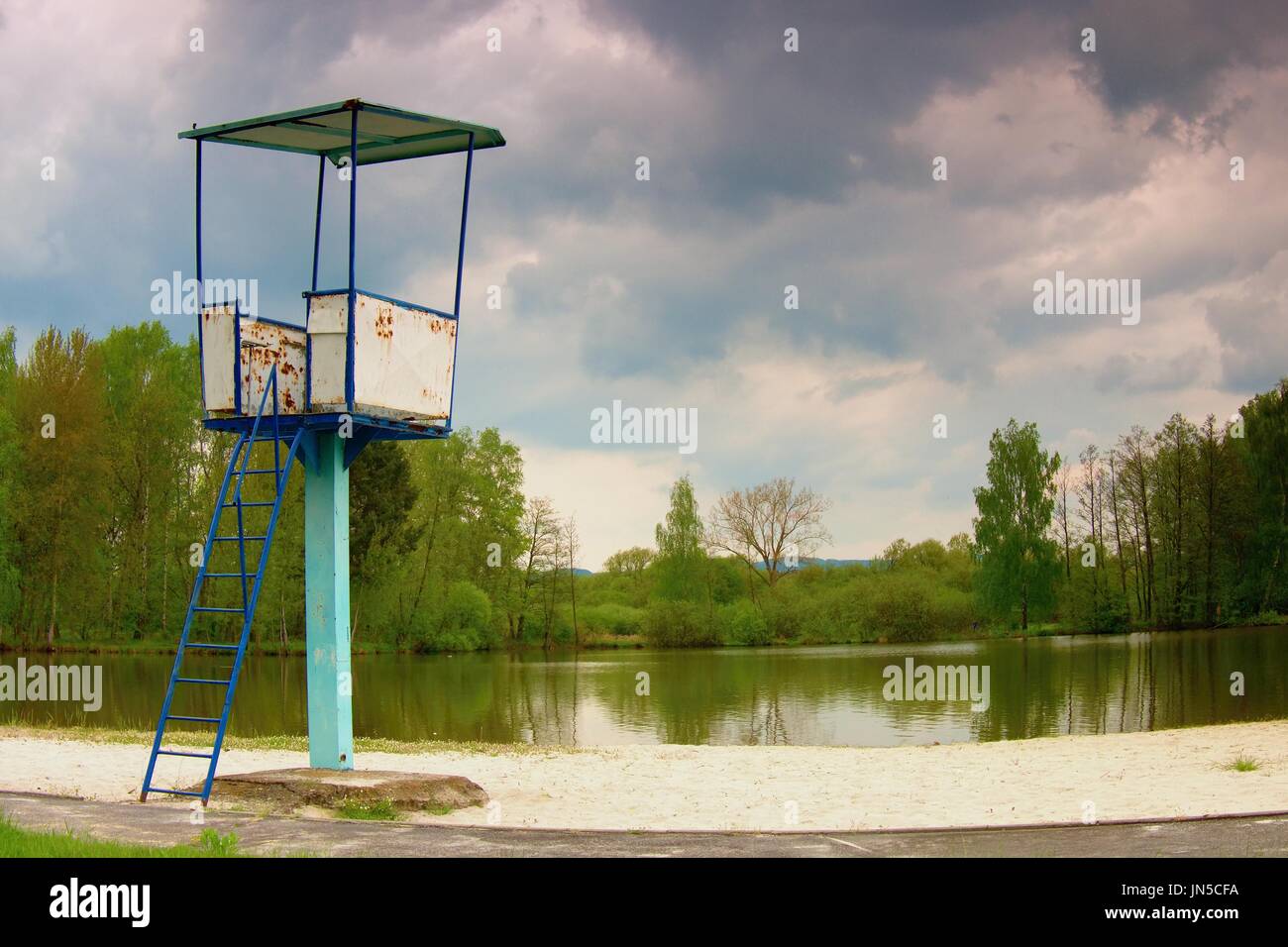 An old white and rusty metal lifeguard tower with chair on a beach ...
