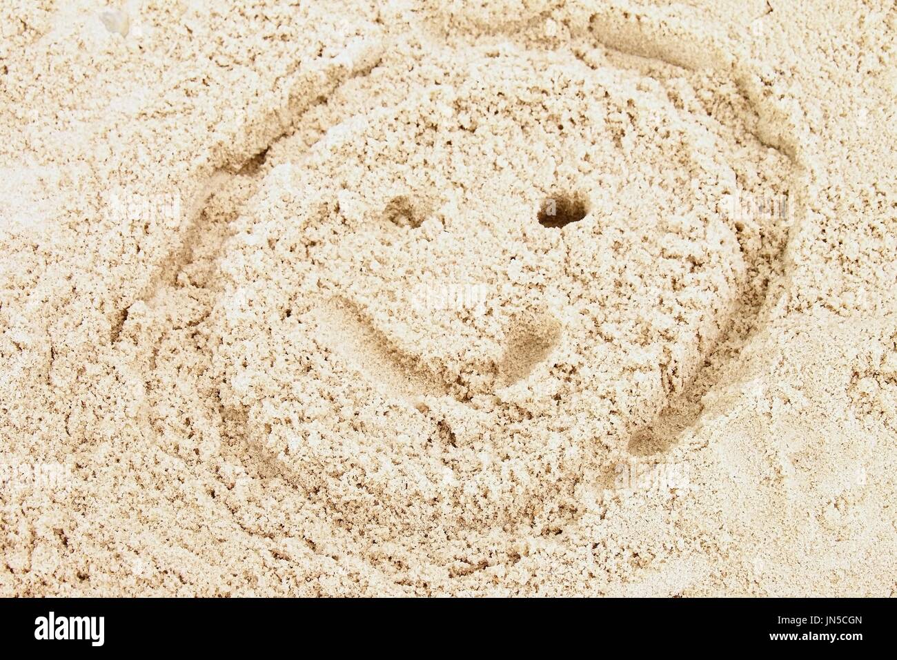 Drawn smiley face in summer beach sand Stock Photo - Alamy