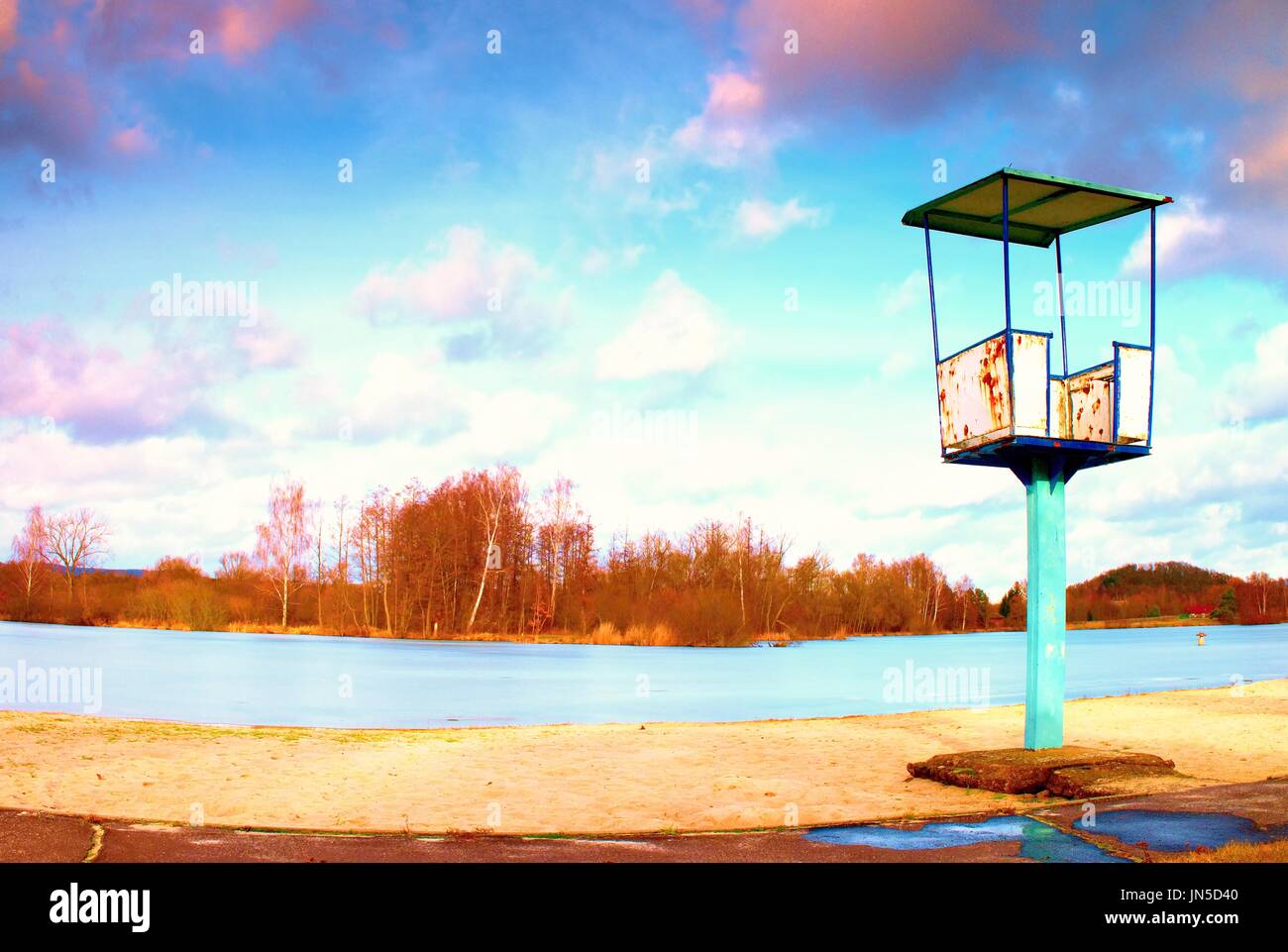 Old white and rusty metal lifeguard tower with chair on a beach. Frozen ...