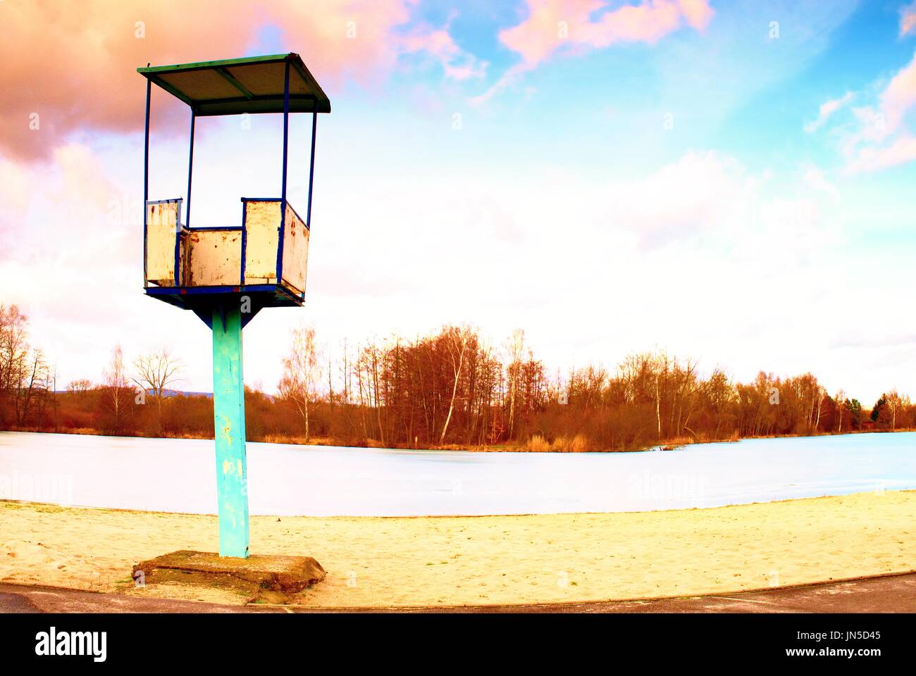 Old white and rusty metal lifeguard tower with chair on a beach. Frozen ...