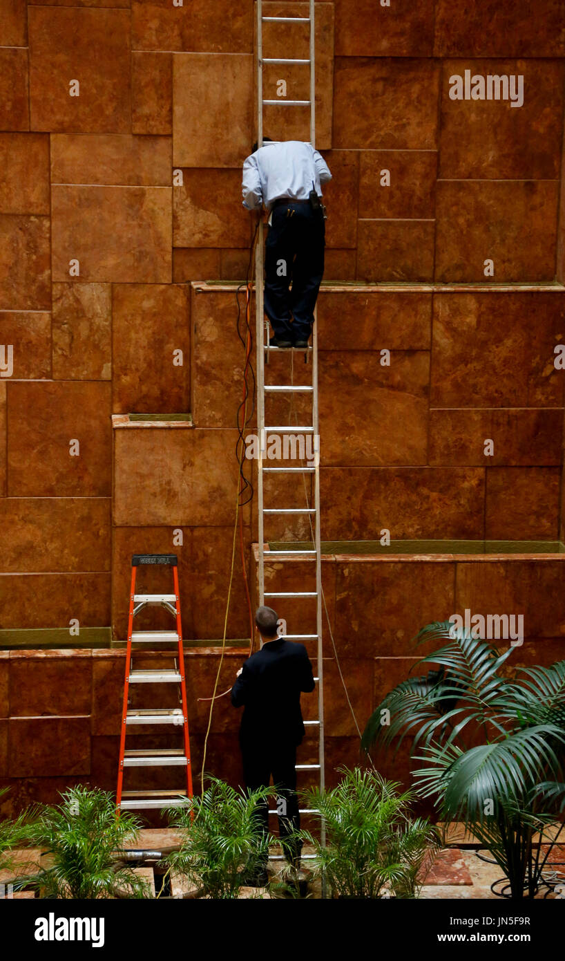 A worker repairs the fountains located in the Trump Tower while United ...