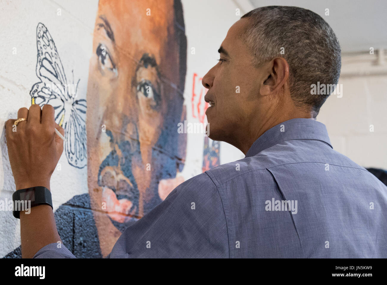 US President Barack Obama helps paint a mural depicting Martin Luther ...