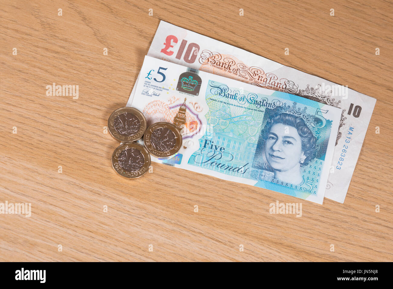 British pound sterling bank notes with coins on wooden background Stock ...