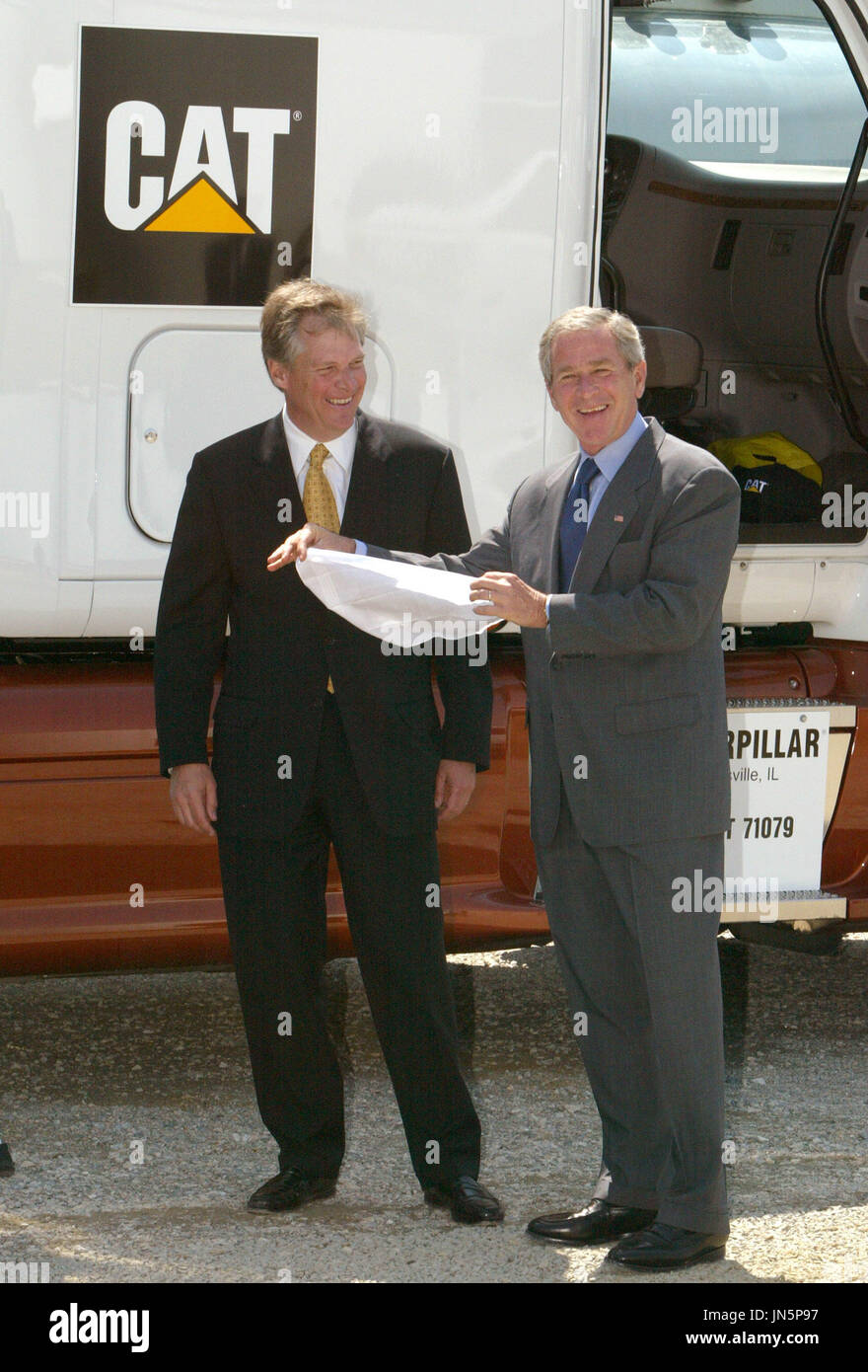 United States President George W. Bush (R) holds up a handkerchief ...