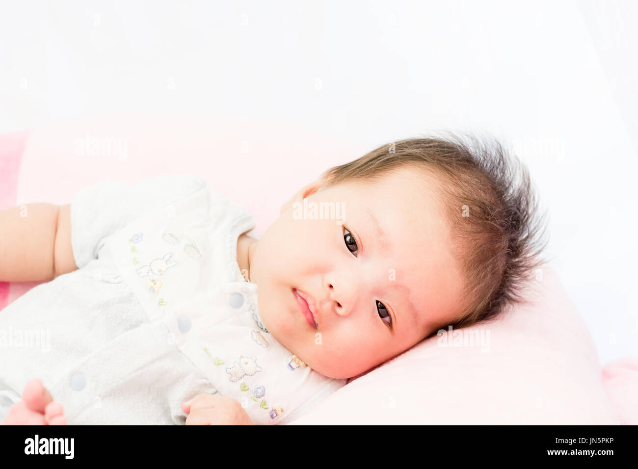 Portrait of a little adorable infant baby girl lying on back on the ...