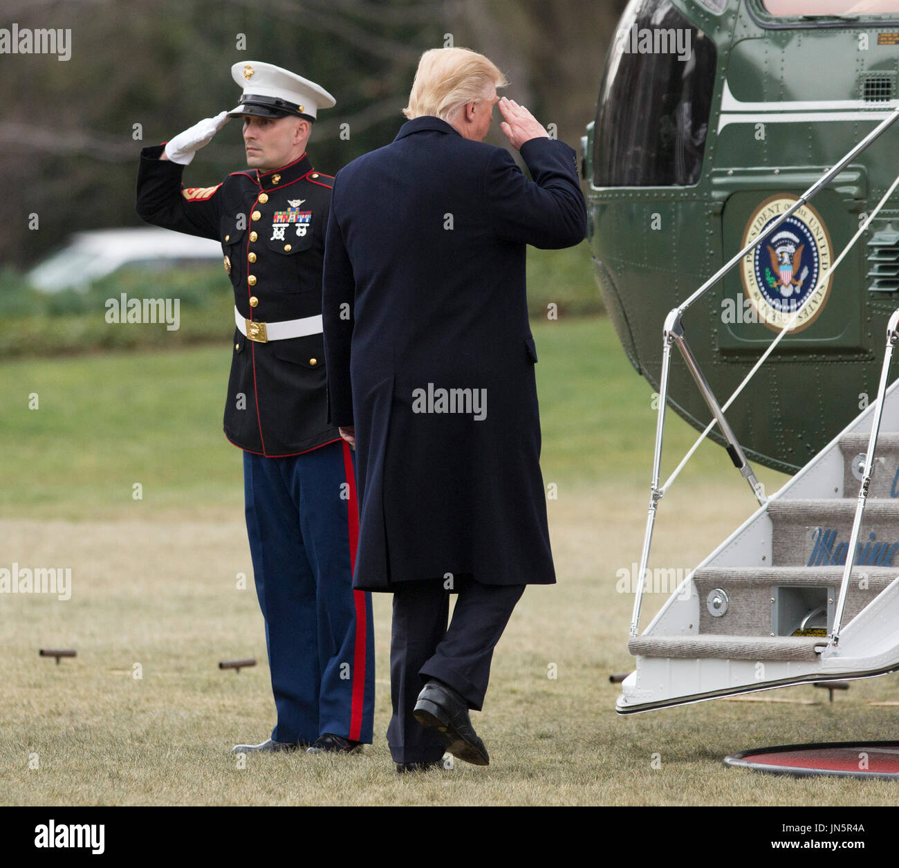 United States President Donald J. Trump salutes the Marine Guard as he ...