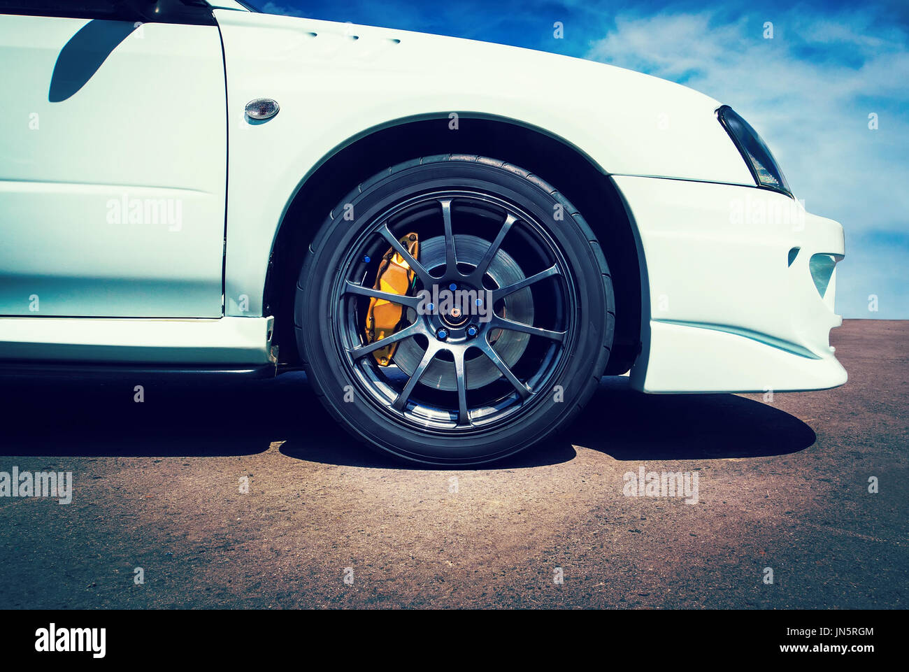 Speed - detail sports car with summer sky. Tuned wheels on cars. The ...