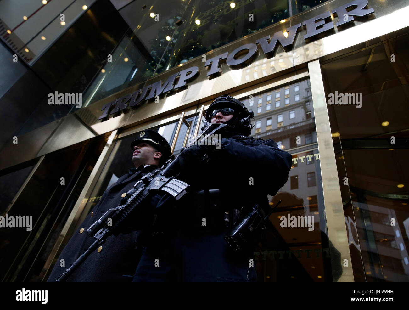 An armed NYPD police officer stands guard outside the entrance to Trump ...