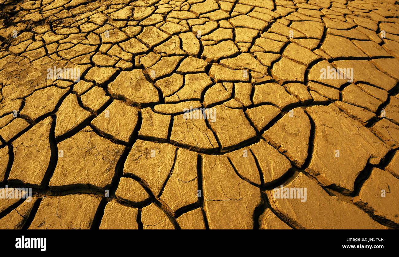 Golden crack earth, dry ground surface, gold brown clay soil texture ...
