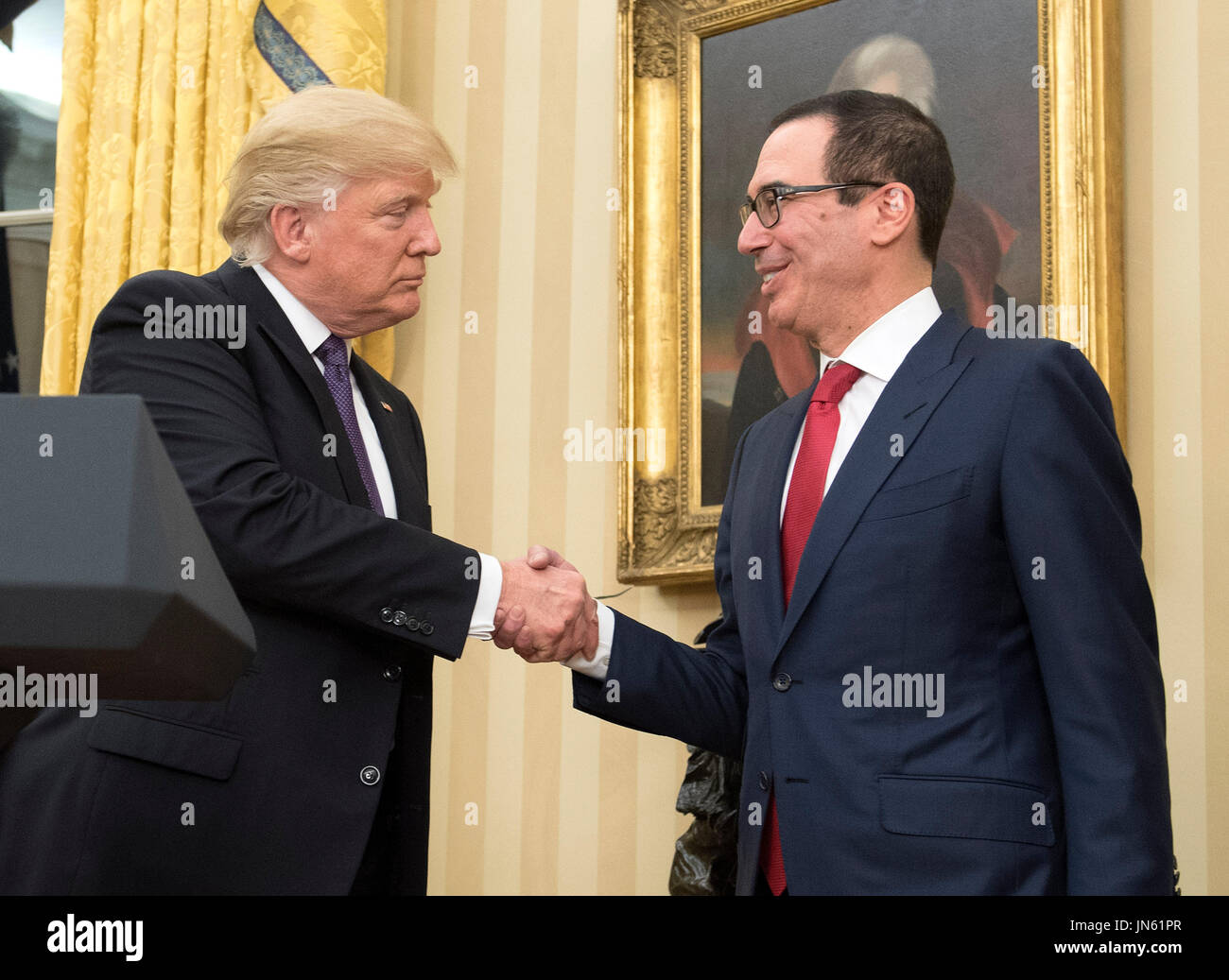 United States President Donald Trump shakes hands with Steven Munchin ...
