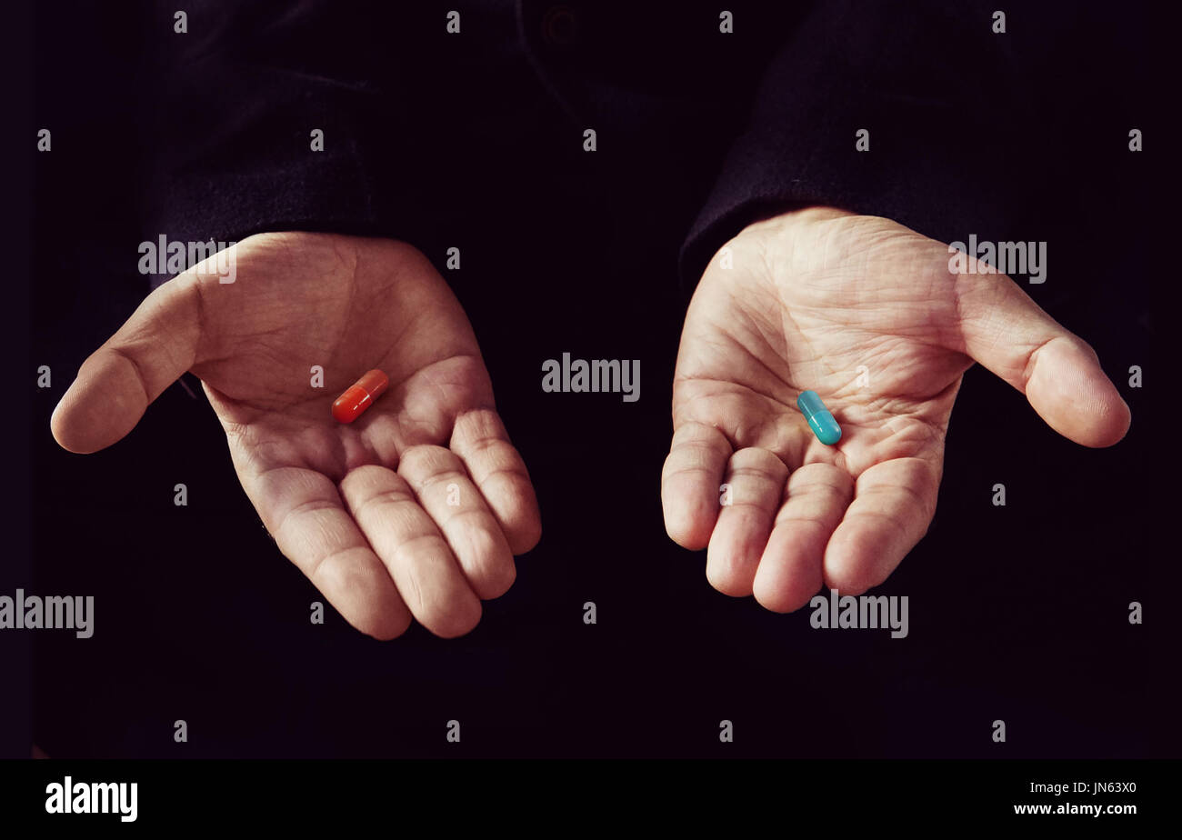 Red tablet in the left palm blue pill in his right hand Stock Photo - Alamy