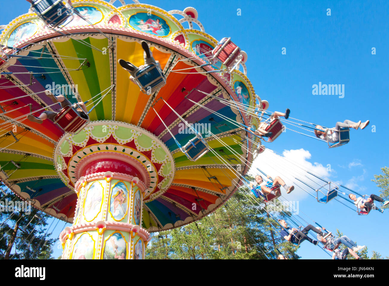 Colorful chain swing carousel in motion at amusement park on blue sky ...