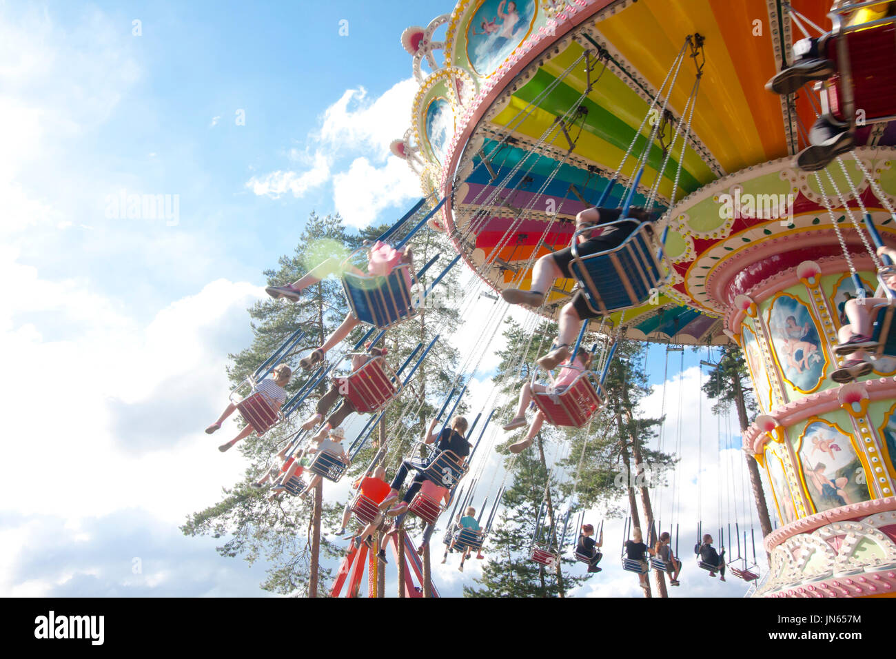 Colorful chain swing carousel in motion at amusement park on blue sky ...