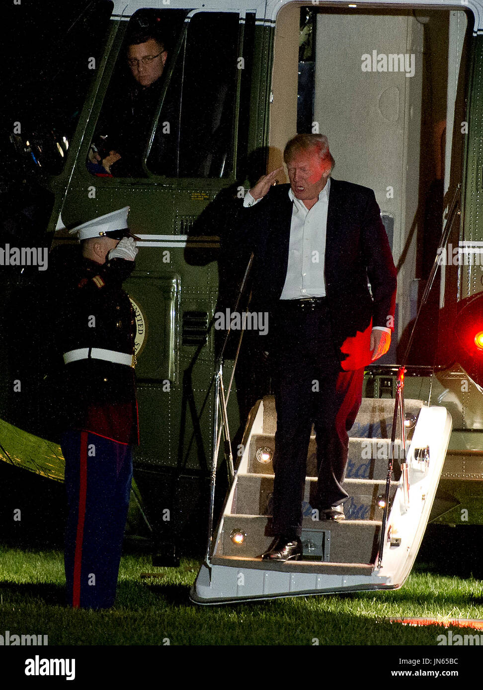United States President Donald J. Trump salutes the Marine Guard as he ...