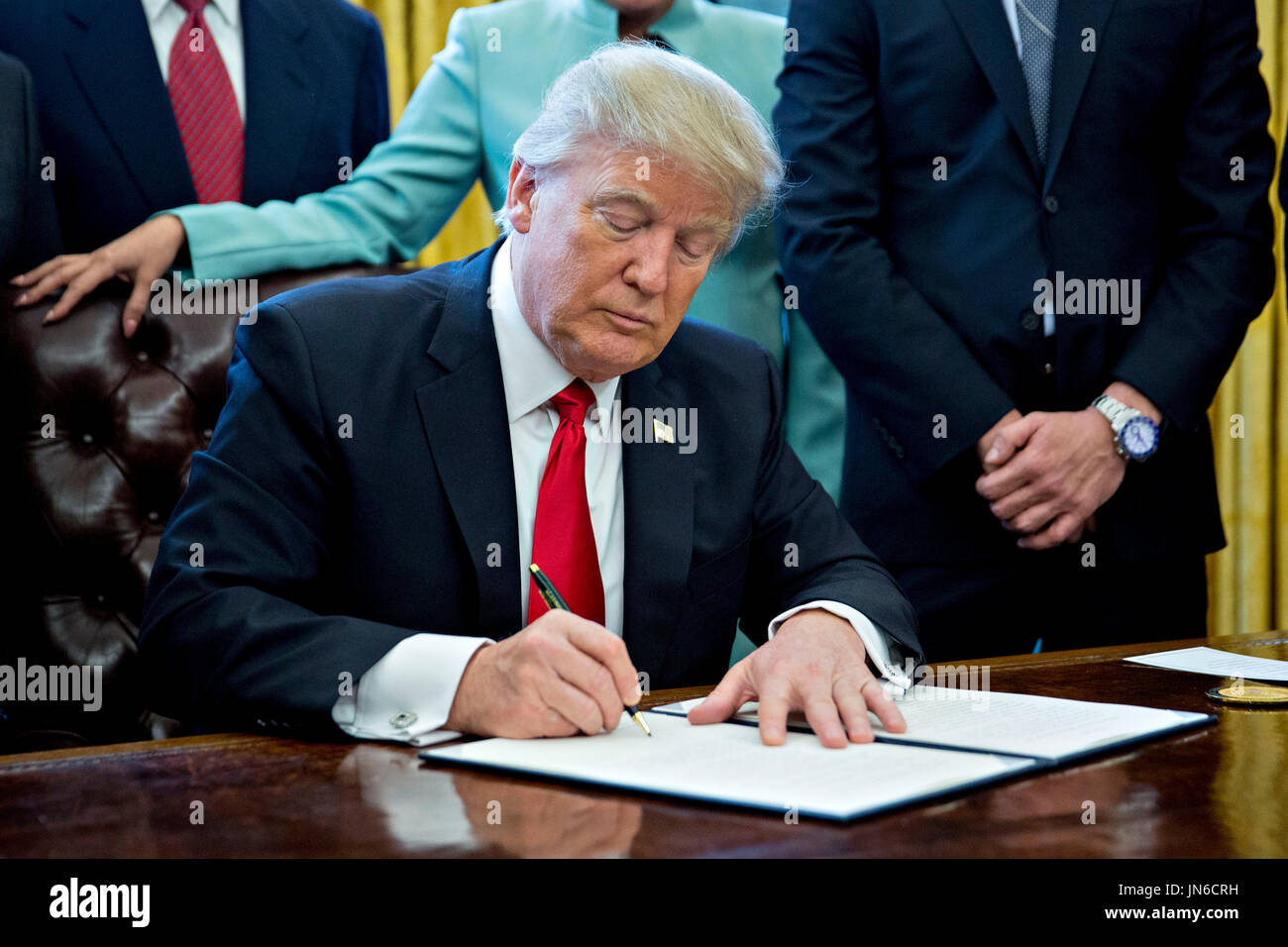 U.S. President Donald Trump signs an executive order in the Oval Office ...