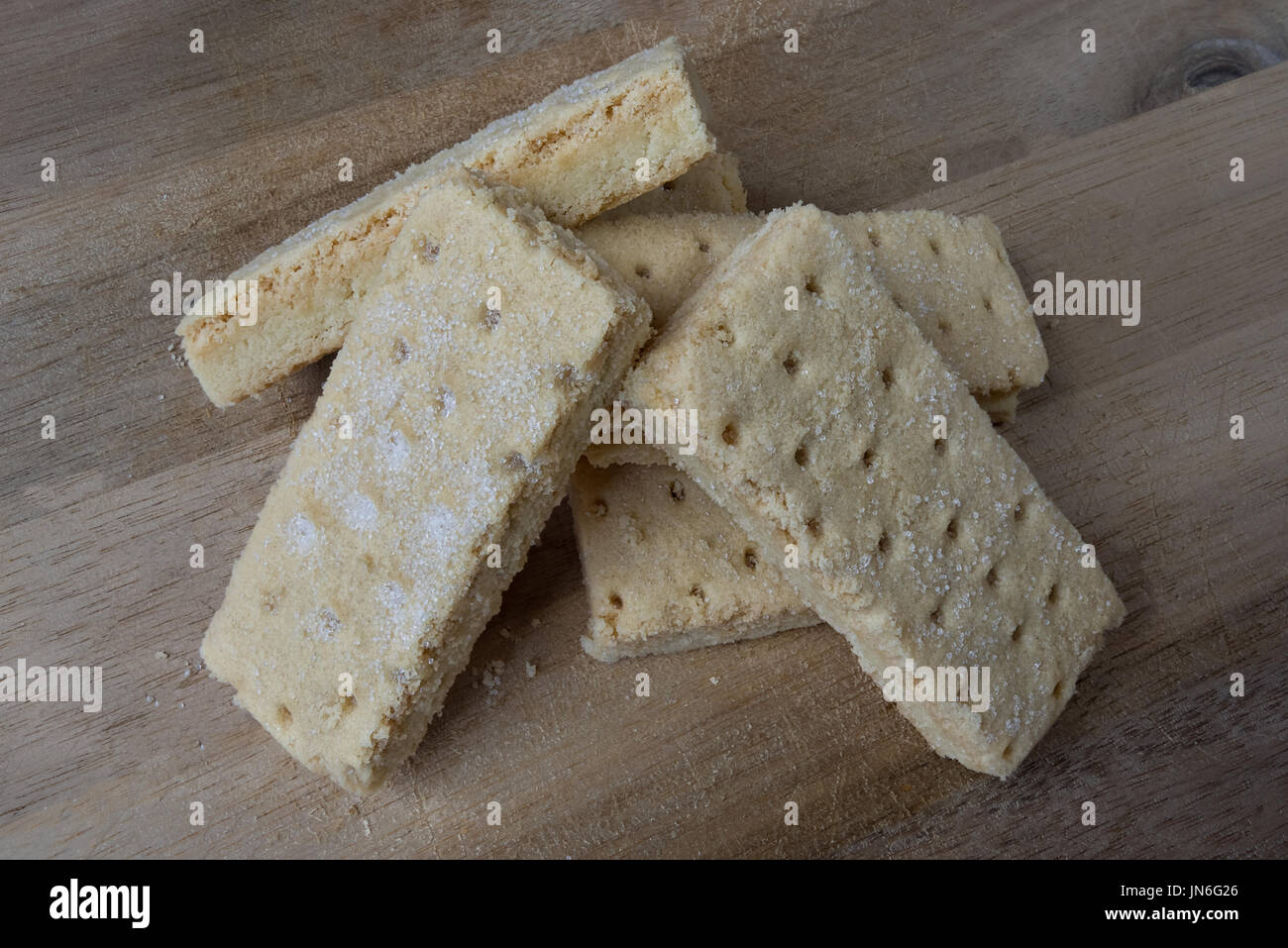 Pilers of shortbread biscuits on a oak serving board and covered in ...