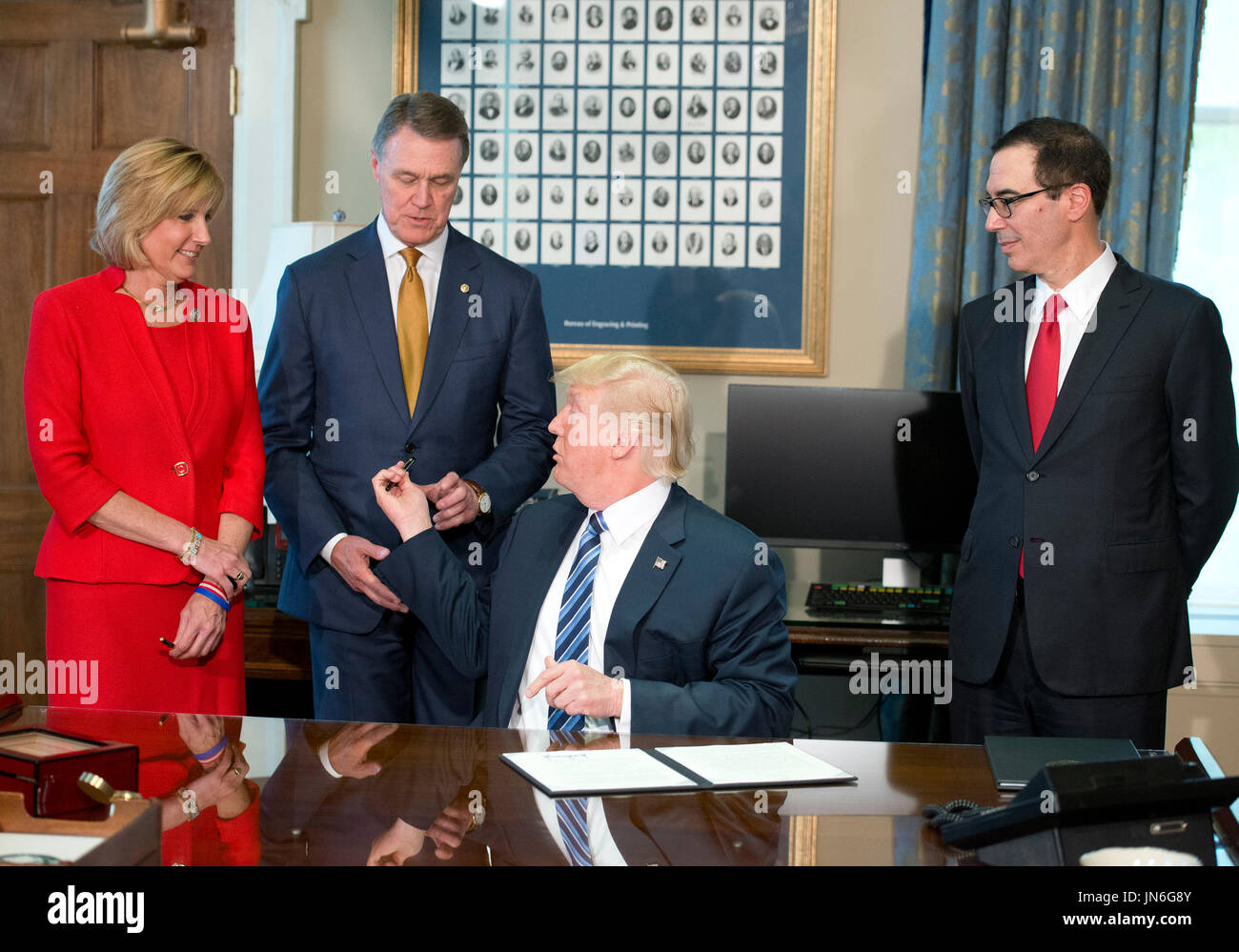 United States President Donald J. Trump hands the pen he used to sign ...