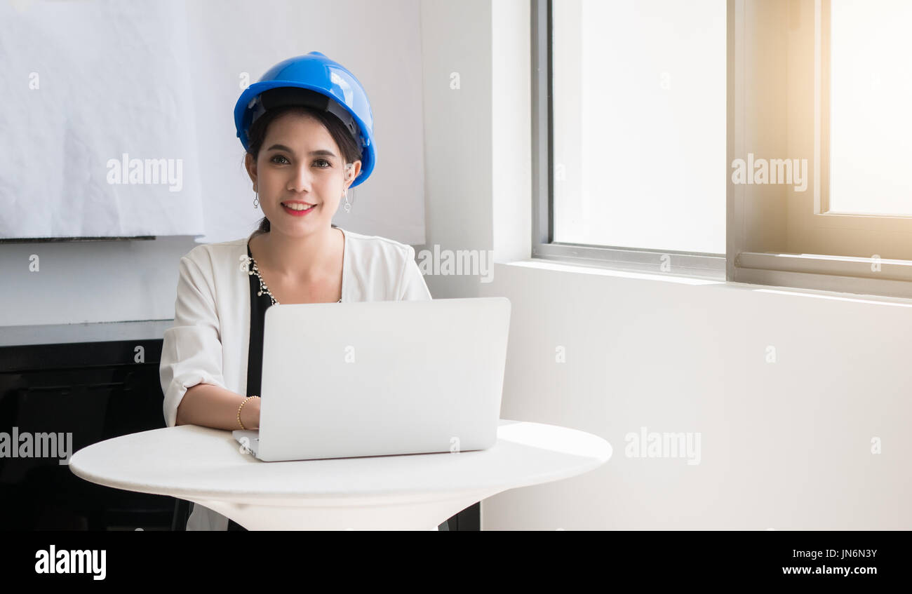 Female engineers wearing helmets and used a computer to plan ...