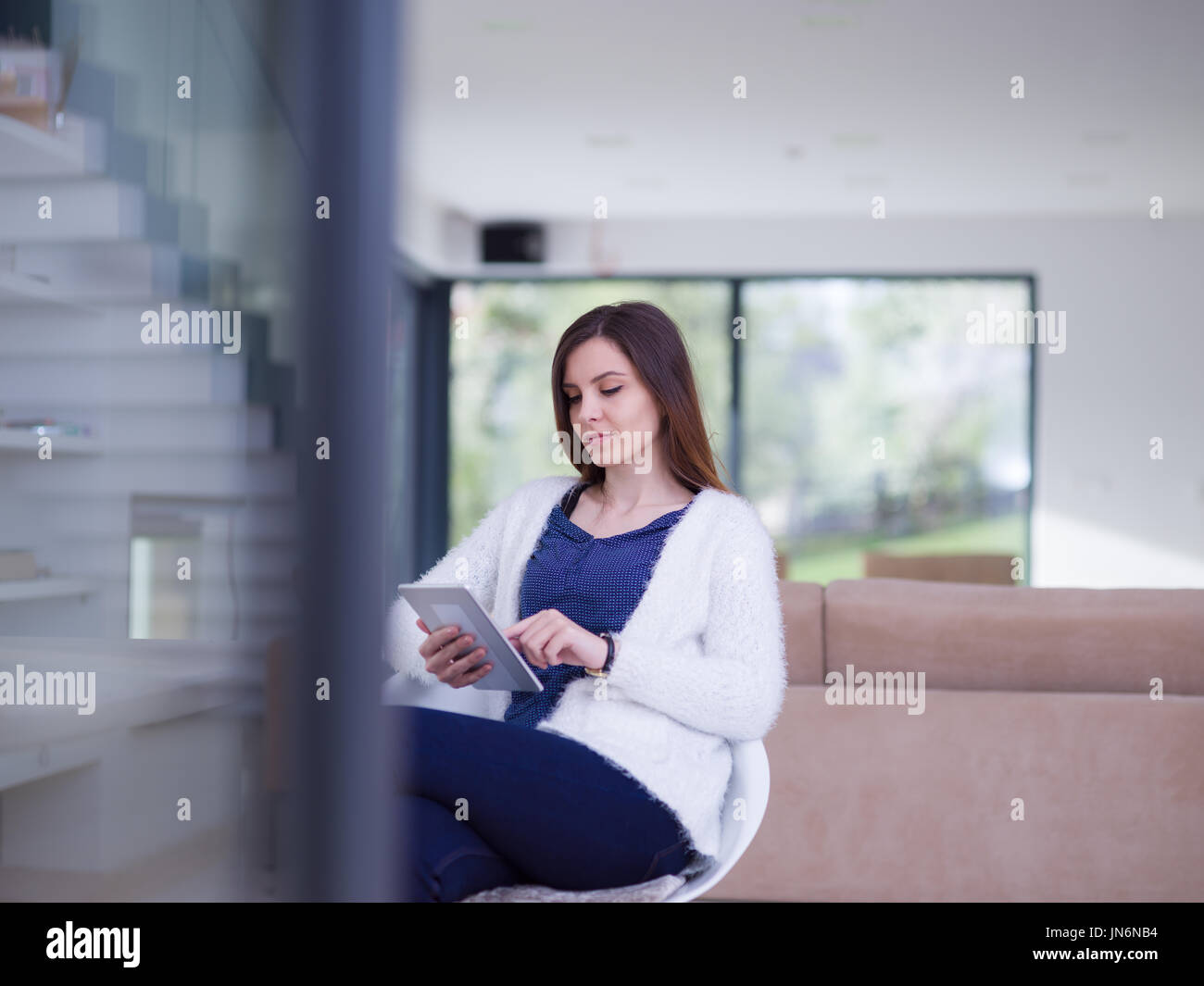 beautiful young women using tablet computer by the window of her luxury ...