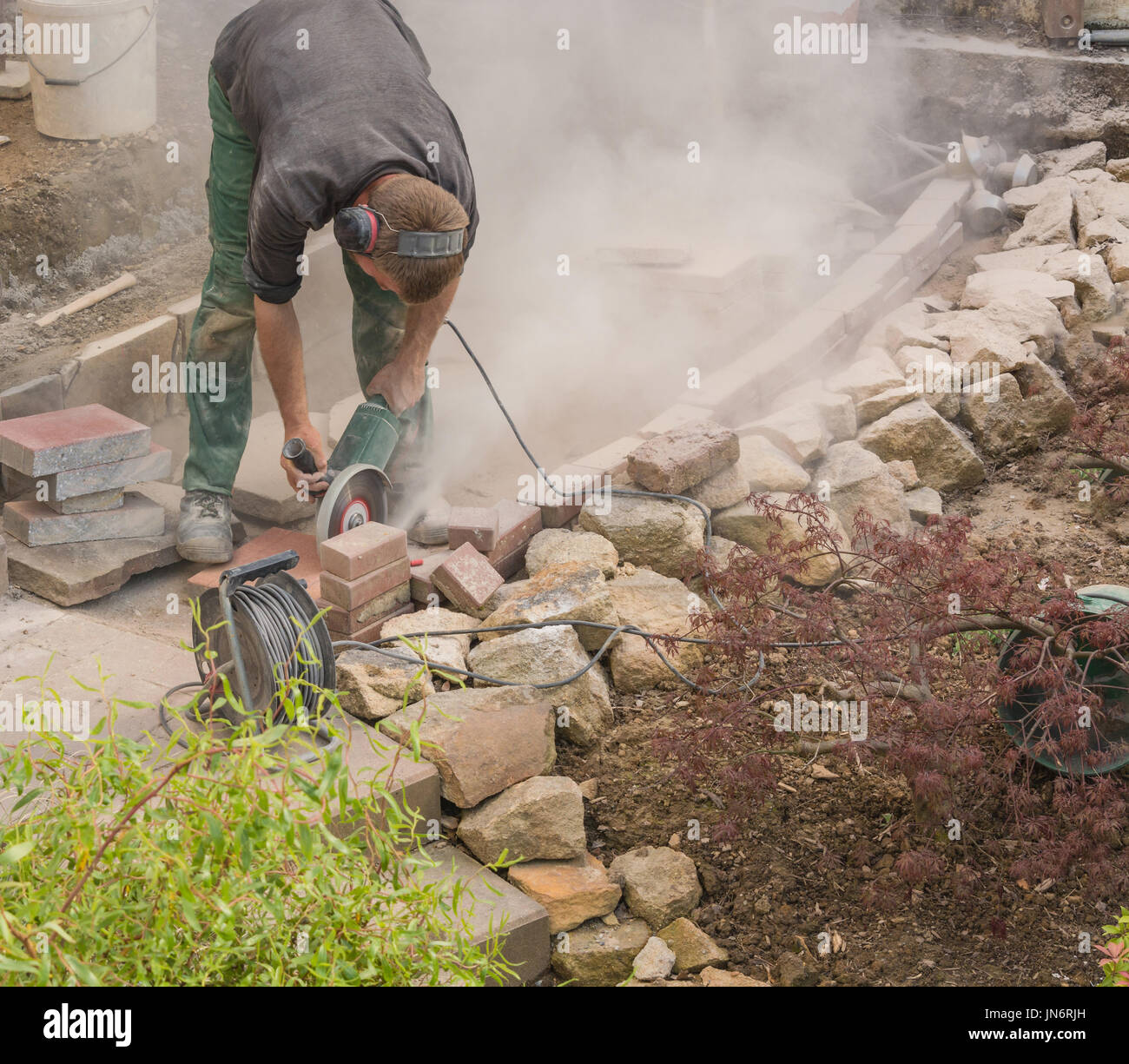 Man cutting stone slabs, concrete slab with an electric grinder Stock ...
