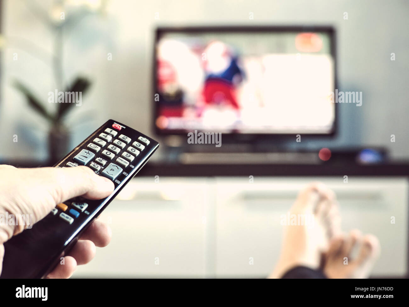 Men with the remote control front of the television. Hand with remote ...