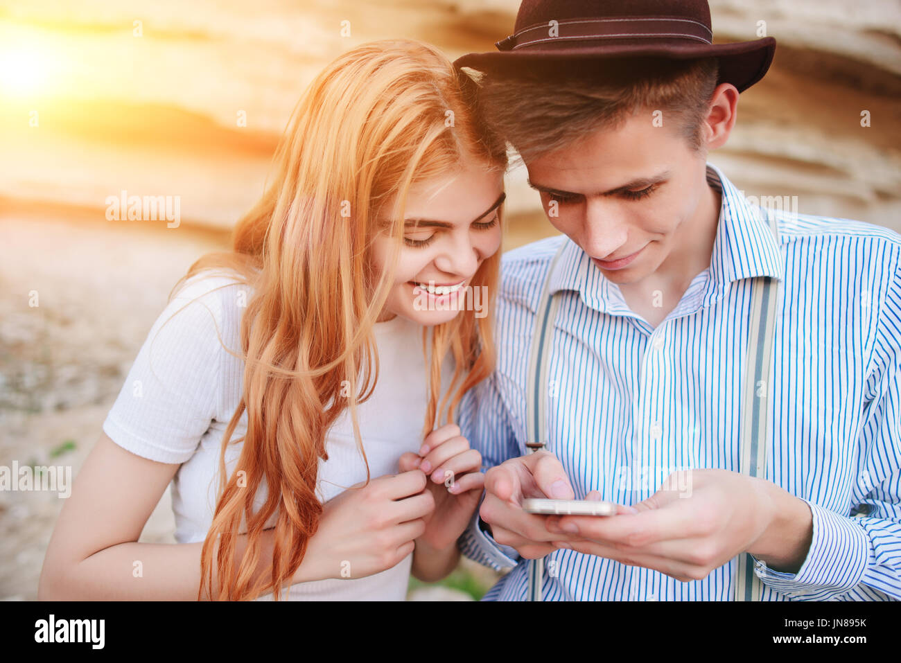 Attractive man and beautiful woman are looking at the screen of a ...