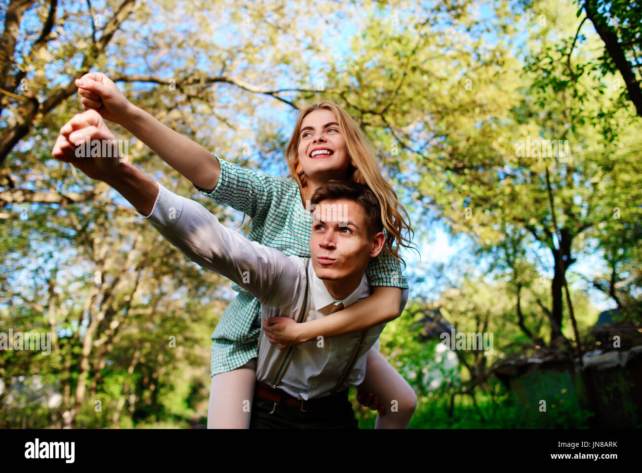 Portrait of happy couple raising their hands in open air Stock Photo ...