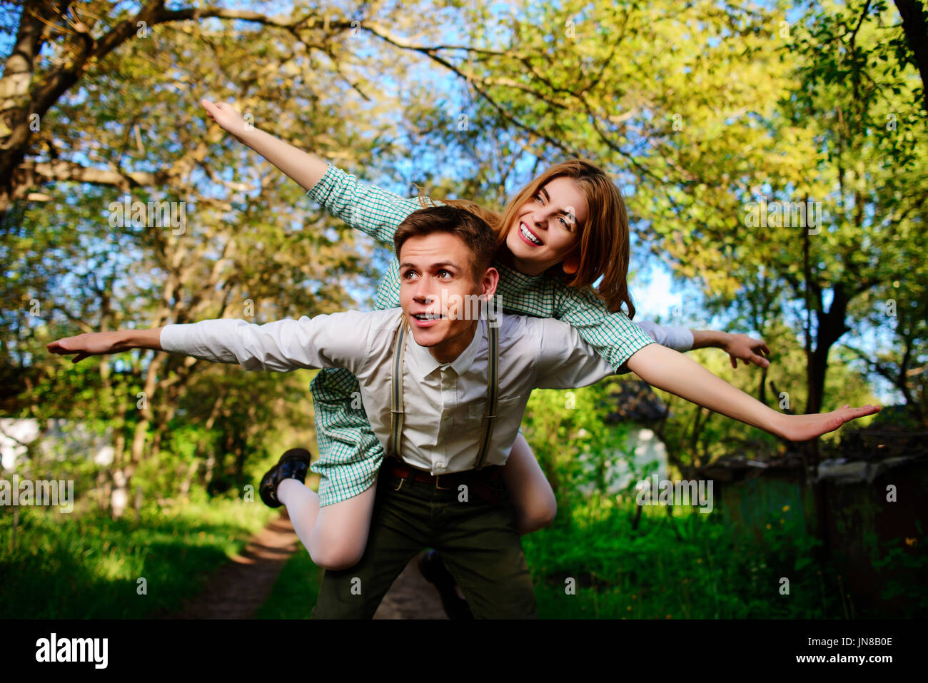 Portrait of happy couple raising their hands in open air Stock Photo ...