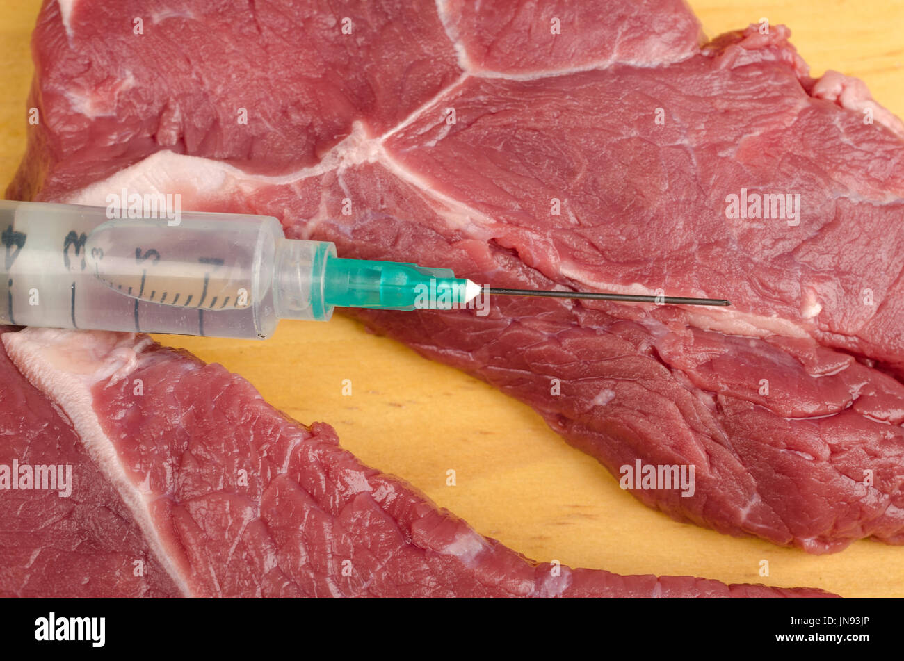 Hormones being injected in a beef steak, a conceptual food manipulation ...