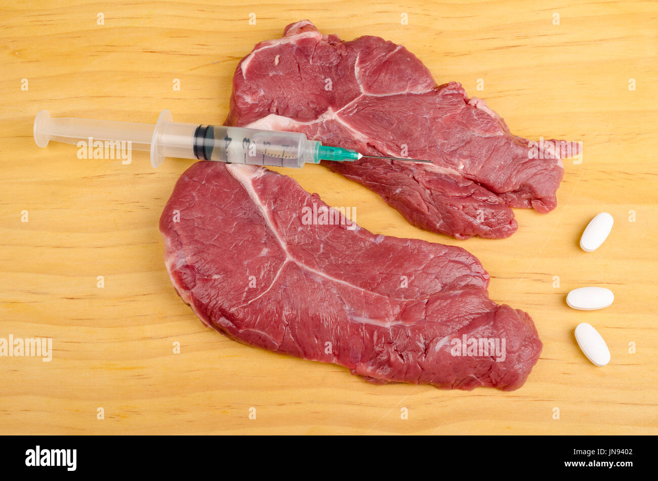 Hormones being injected in a beef steak, a conceptual food manipulation ...
