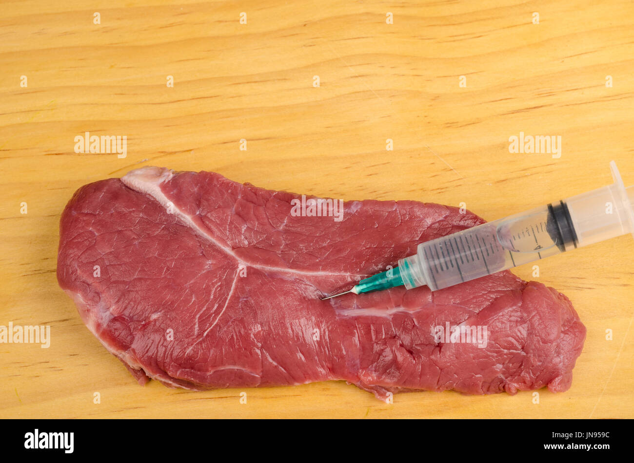 Hormones being injected in a beef steak, a conceptual food manipulation ...