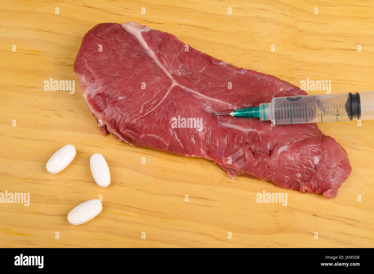 Hormones being injected in a beef steak, a conceptual food manipulation ...